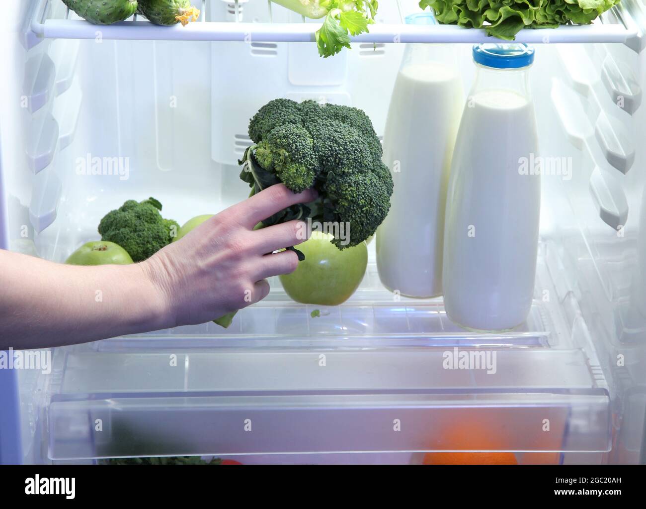 Woman's hand reaching out for food from the refrigerator, close up ...