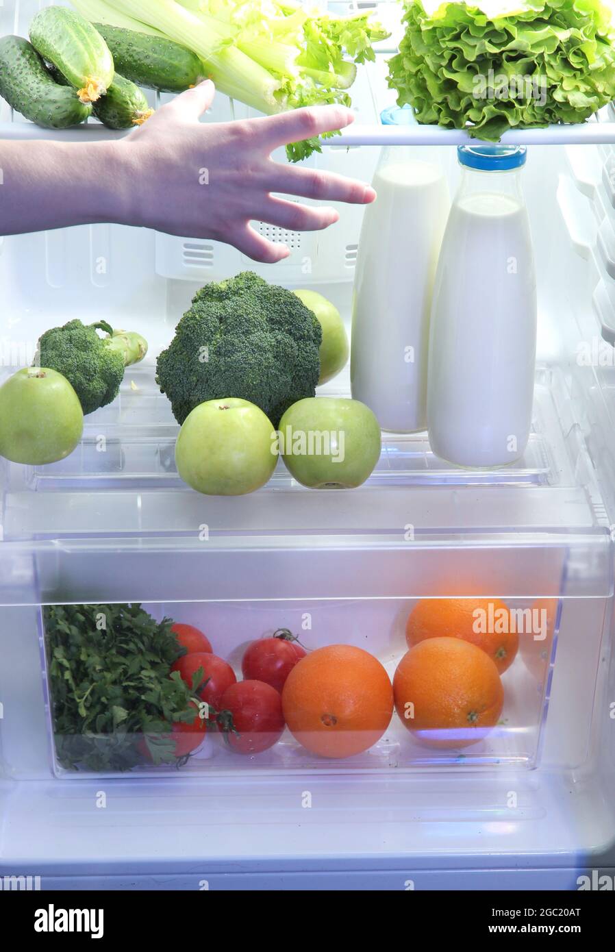 Woman's hand reaching out for food from the refrigerator, close up ...