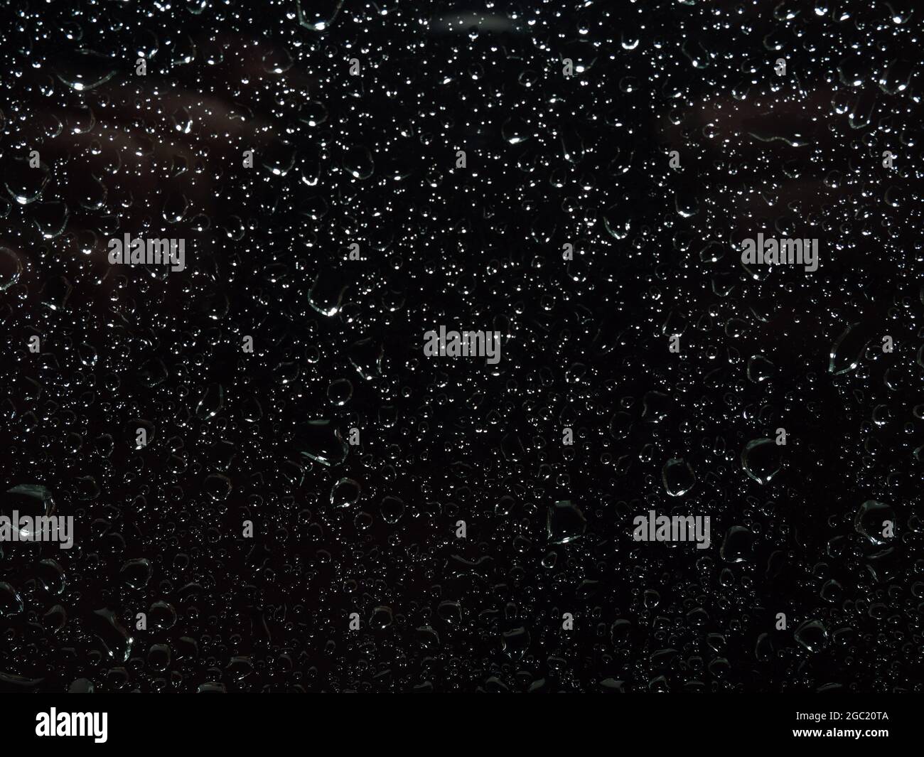 Rain droplets running down on a window glass, abstract backlight ...