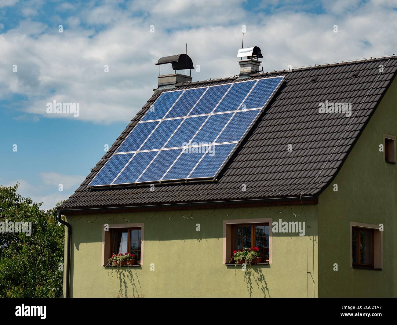 Common solar panels on modern roof with dark blue photocell, replacing ...