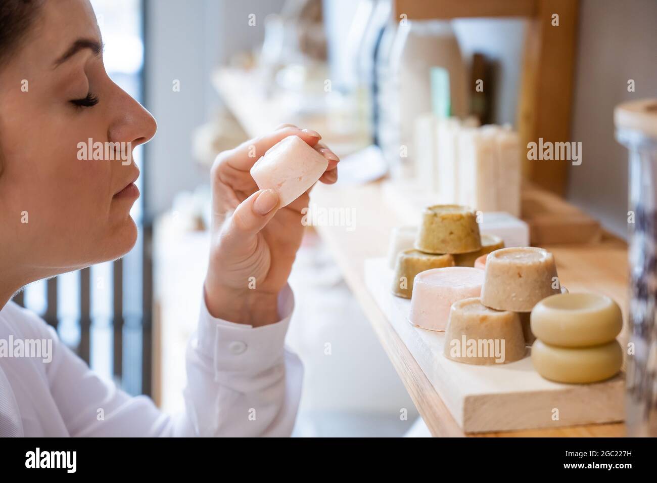 Woman sniffing organic soap while choosing at eco friendly store Stock ...