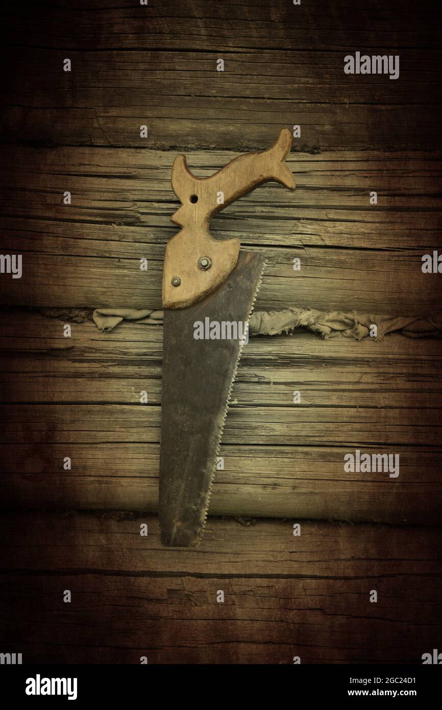 Old one-hand saw with wooden handle hanging on the wall Stock Photo - Alamy