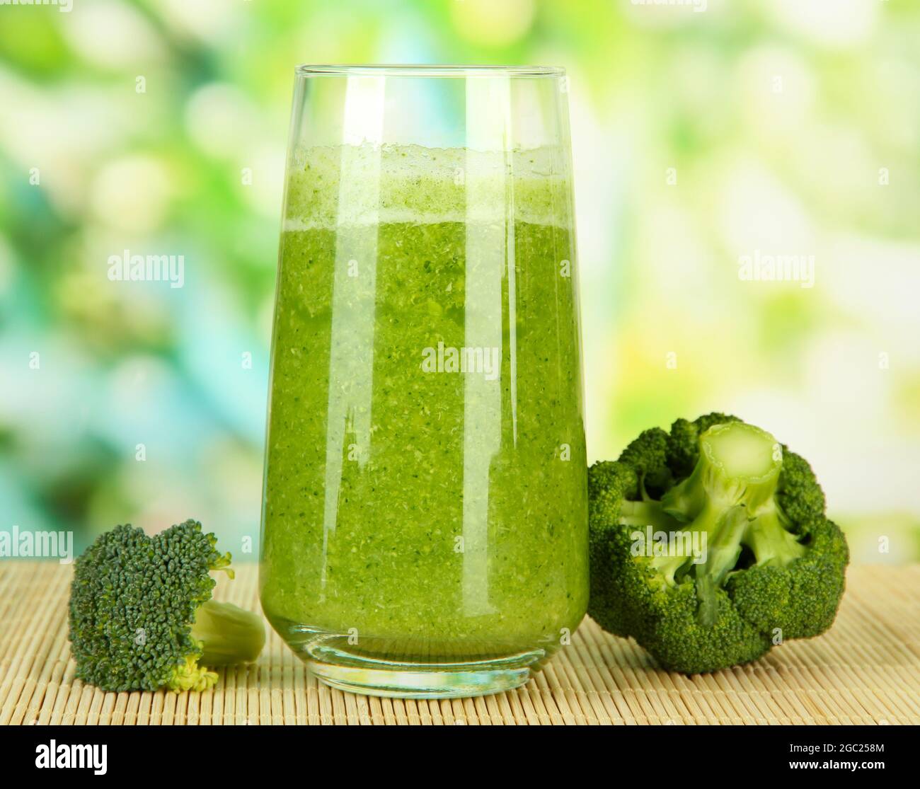 Glass of broccoli juice, on bamboo mat, on green background Stock Photo ...