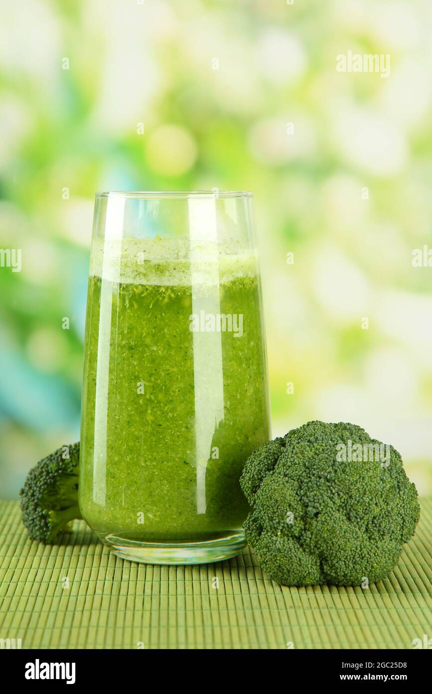 Glass of broccoli juice, on bamboo mat, on green background Stock Photo ...