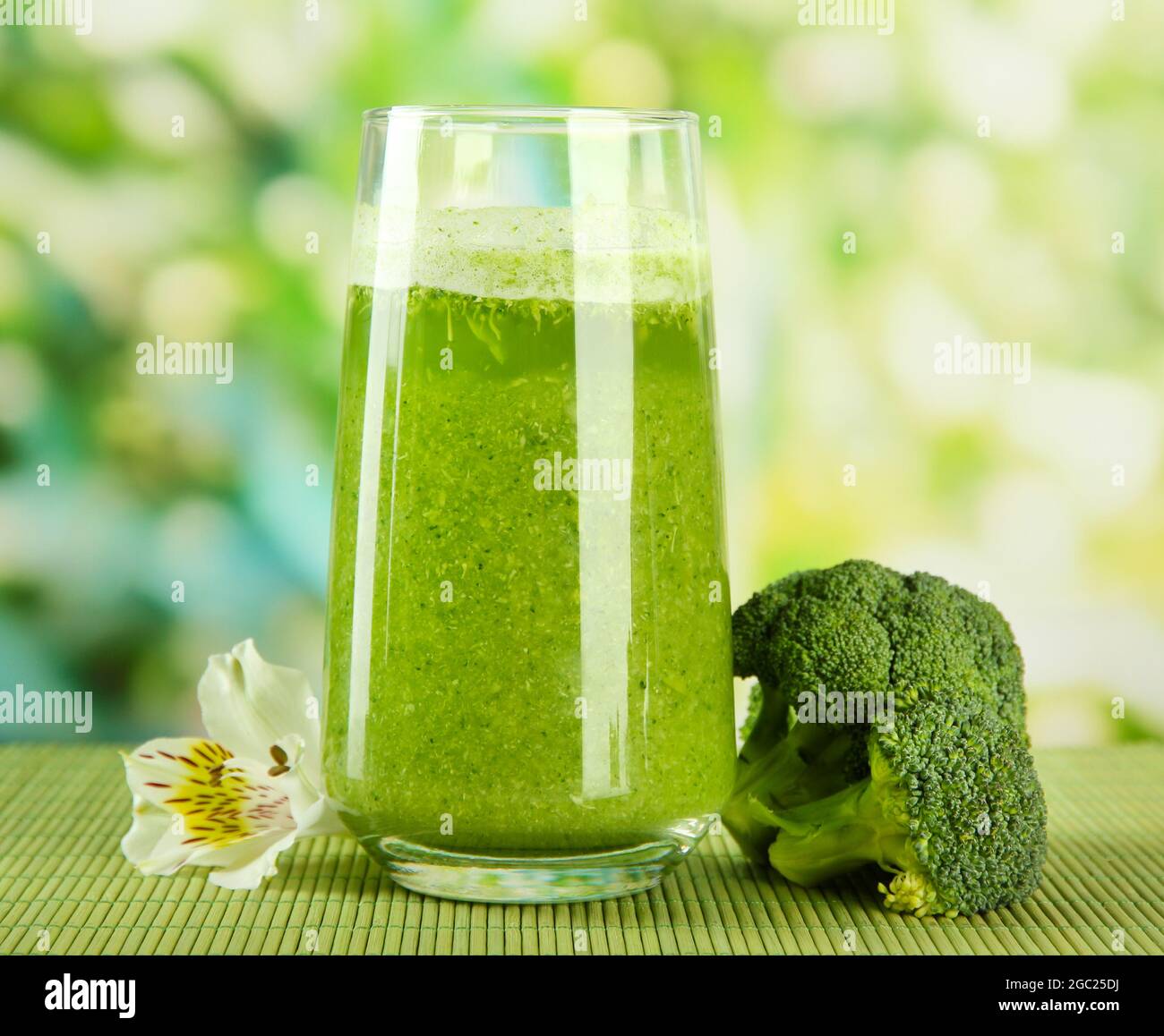 Glass of broccoli juice, on bamboo mat, on green background Stock Photo ...