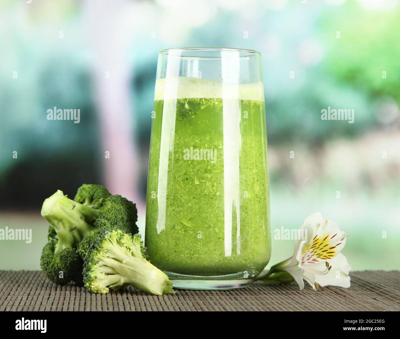 Glass of broccoli juice, on bamboo mat, on green background Stock Photo ...