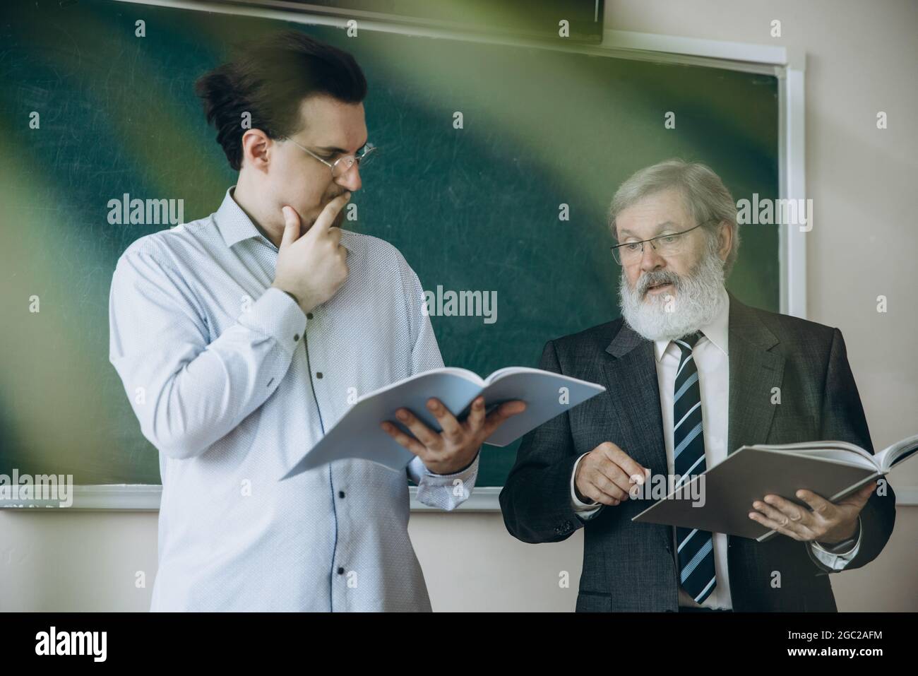 Elderly gray-headed man, professor, teacher and student at lecture ...