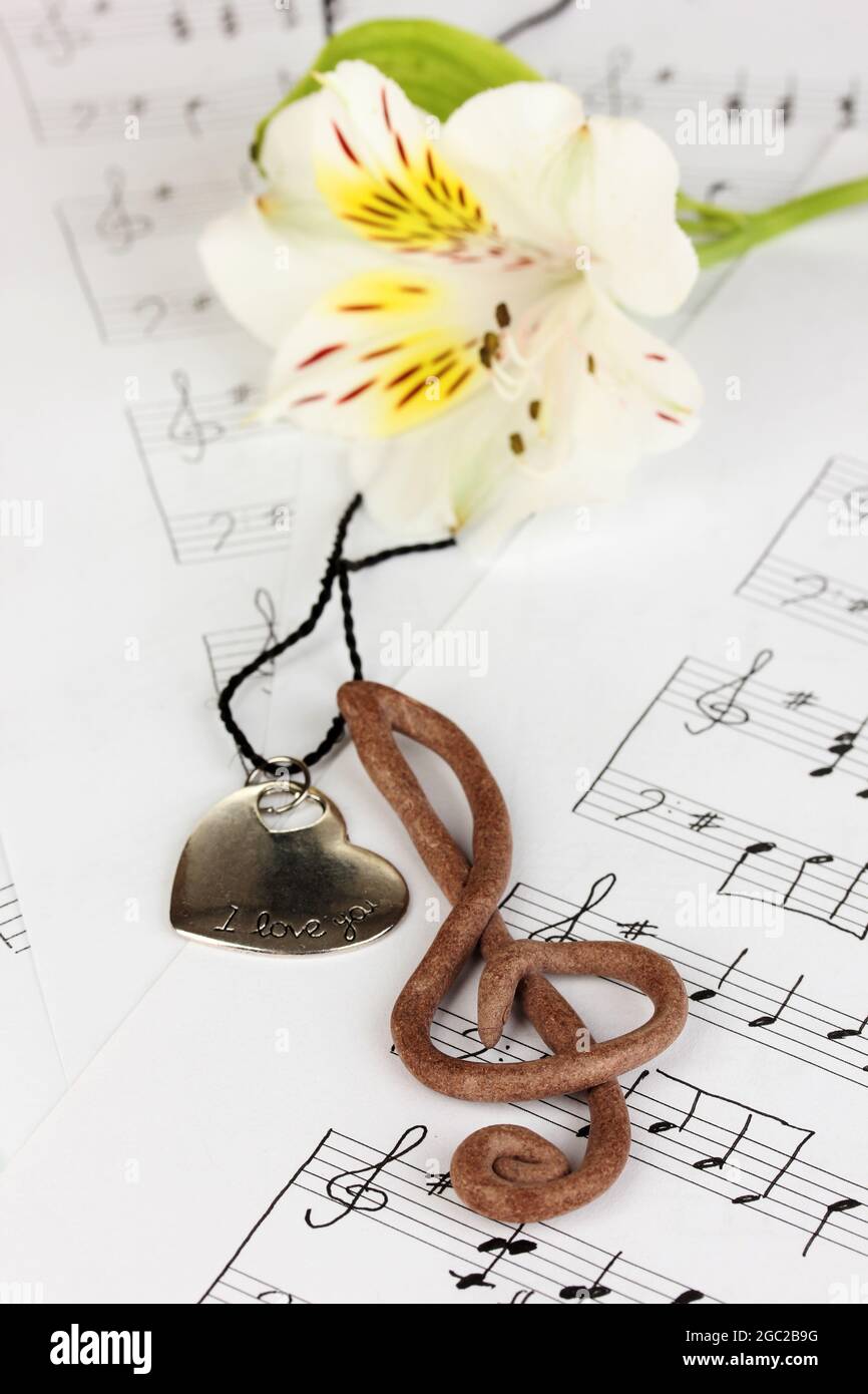 Treble clef, pendant and flower on musical background Stock Photo - Alamy