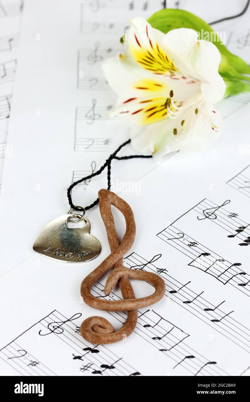 Treble clef, pendant and flower on musical background Stock Photo - Alamy