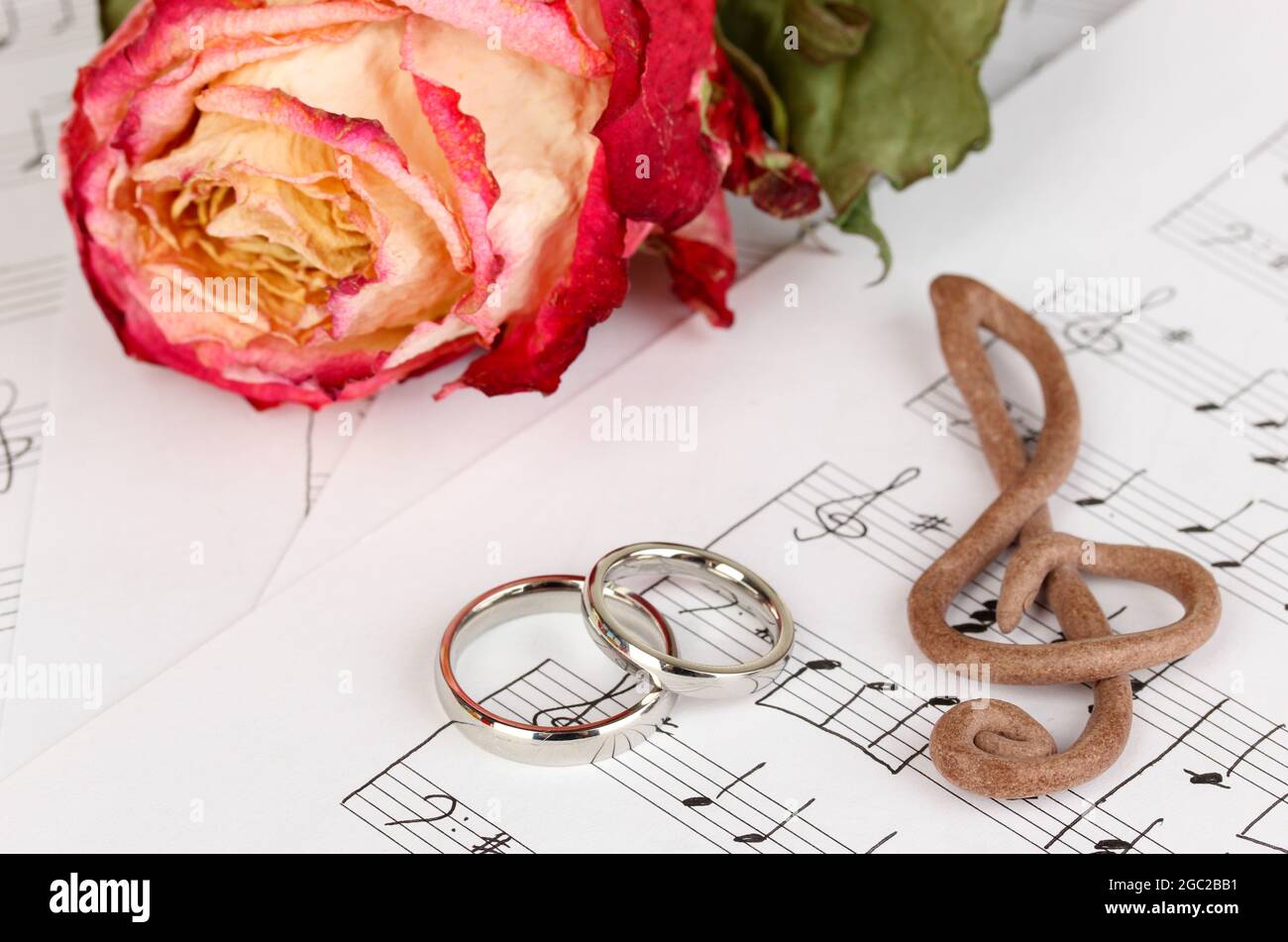 Treble clef, roses and wedding rings on musical background Stock Photo ...