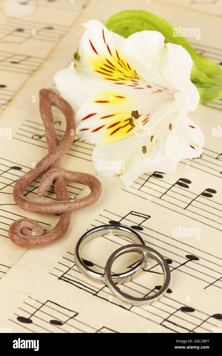 Treble clef, flower and wedding rings on musical background Stock Photo ...
