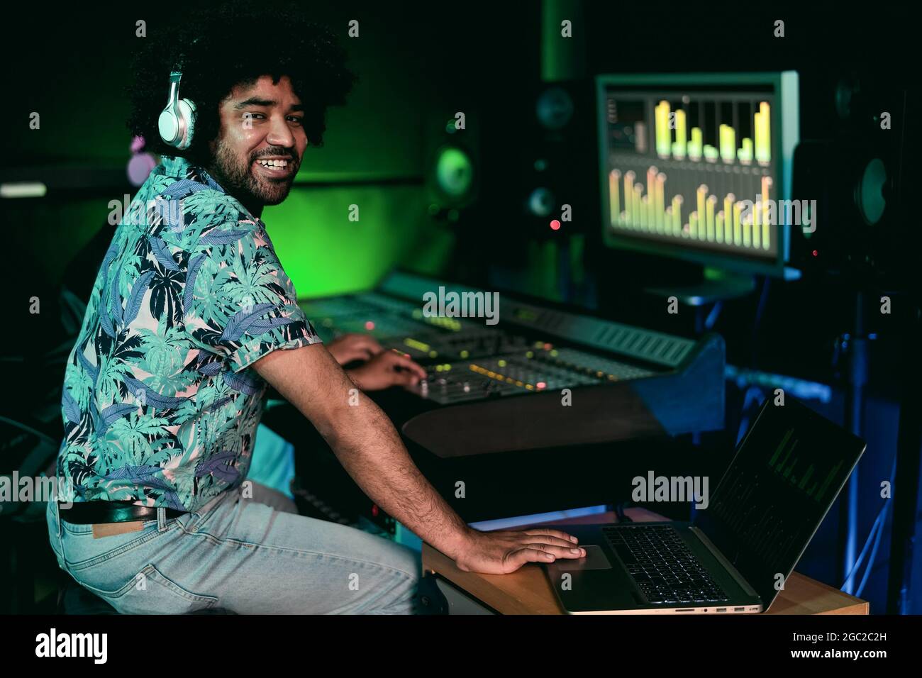 Young Afro man working in music recording studio - Male audio engineer ...