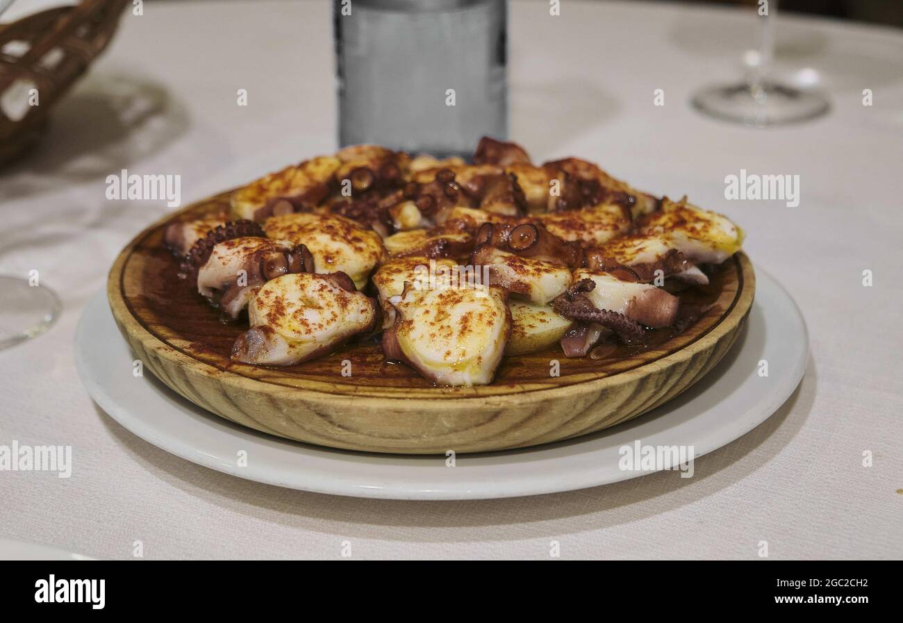 Traditional Galician octopus dish on a wooden tray Stock Photo - Alamy