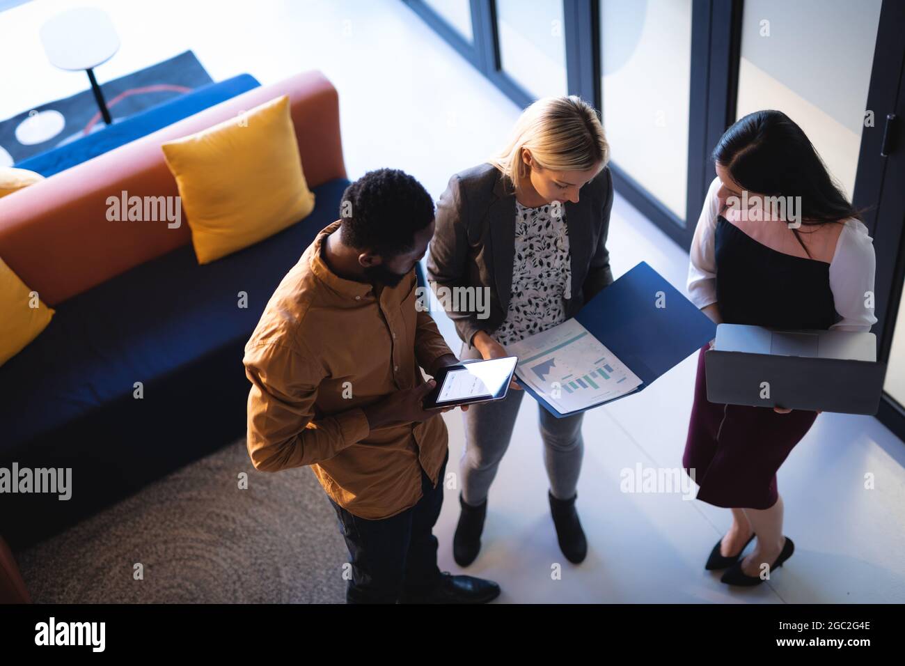 Diverse group of business colleagues holding documents and having ...