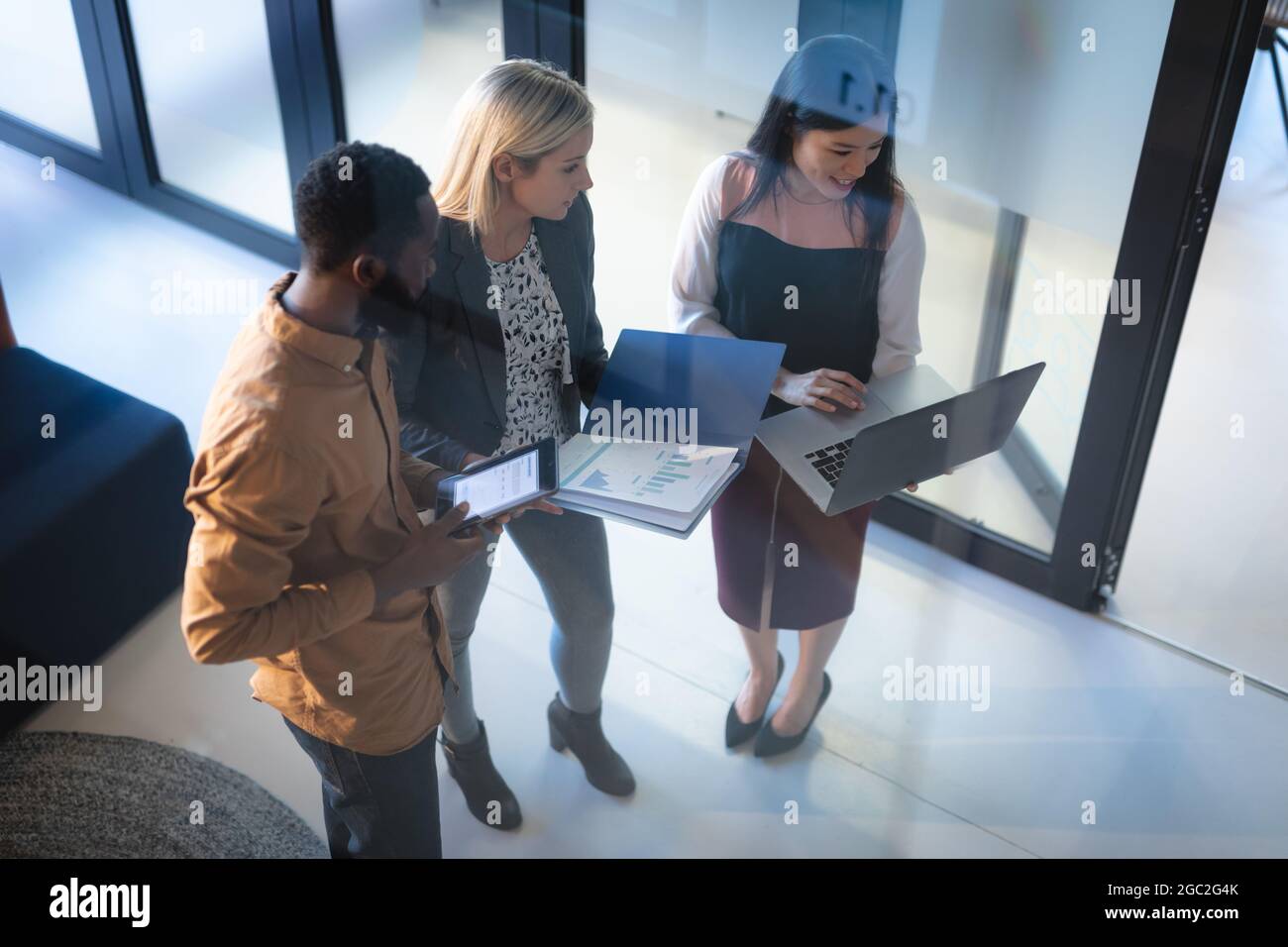 Diverse group of business colleagues holding documents and having ...