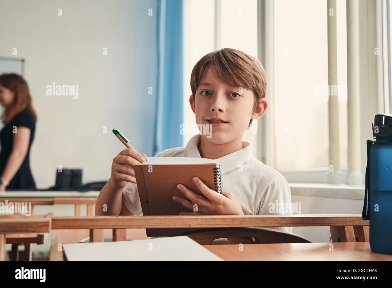 Confident pupil sitting by the window in his classroom Stock Photo - Alamy
