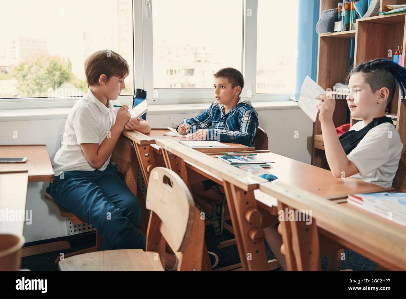Calm schoolchildren studying in modern comfortable classroom Stock ...