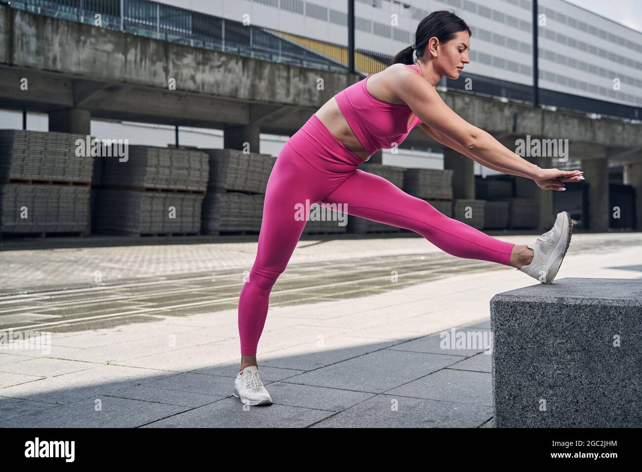 Female bending forward while doing leg stretch Stock Photo - Alamy