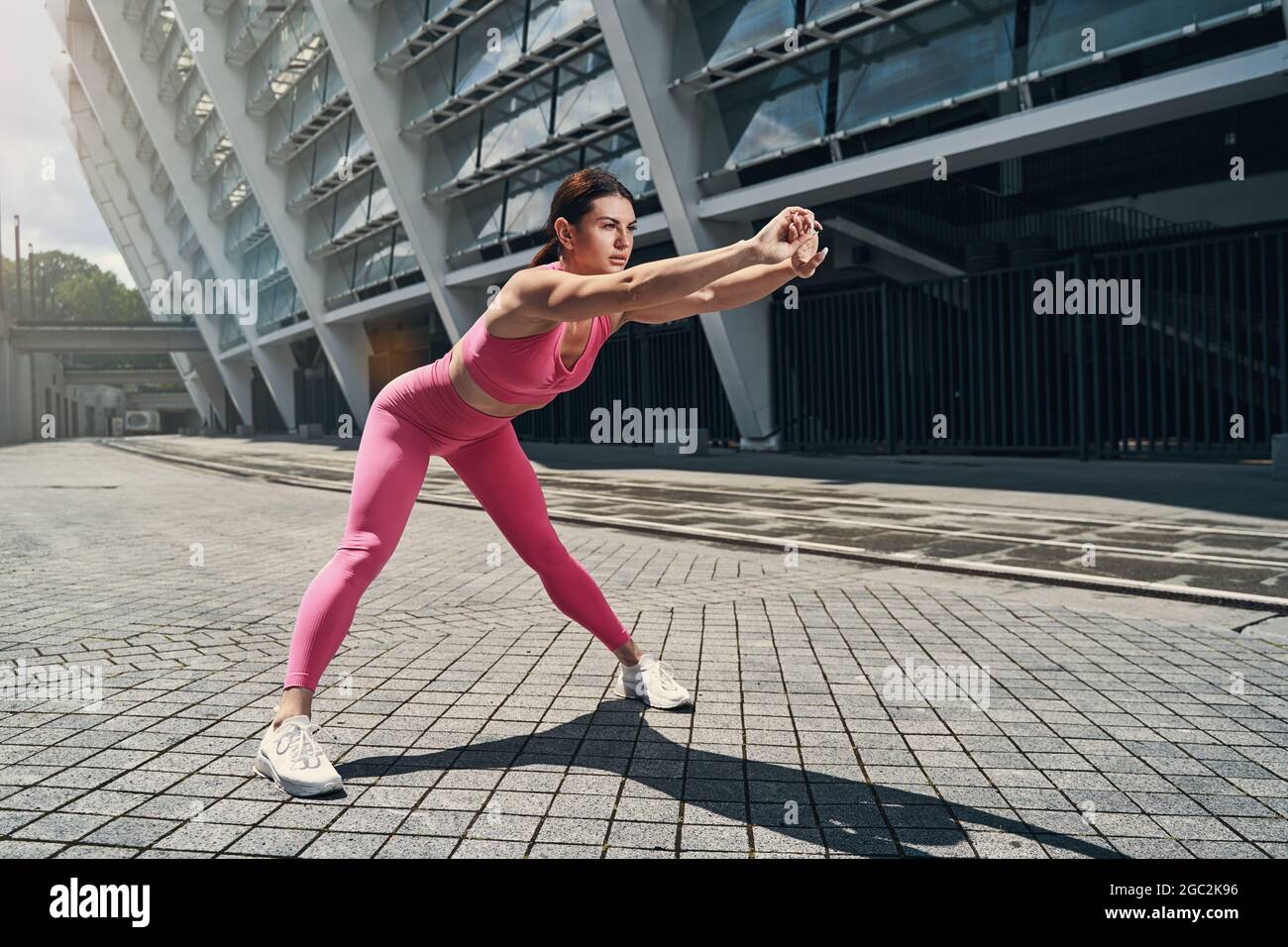 Active female leaning forward and stretching arms Stock Photo - Alamy