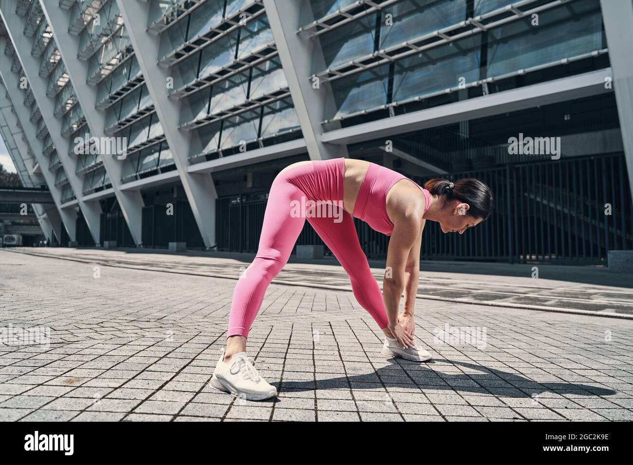 Female is leaning and stretching hands to left foot Stock Photo - Alamy
