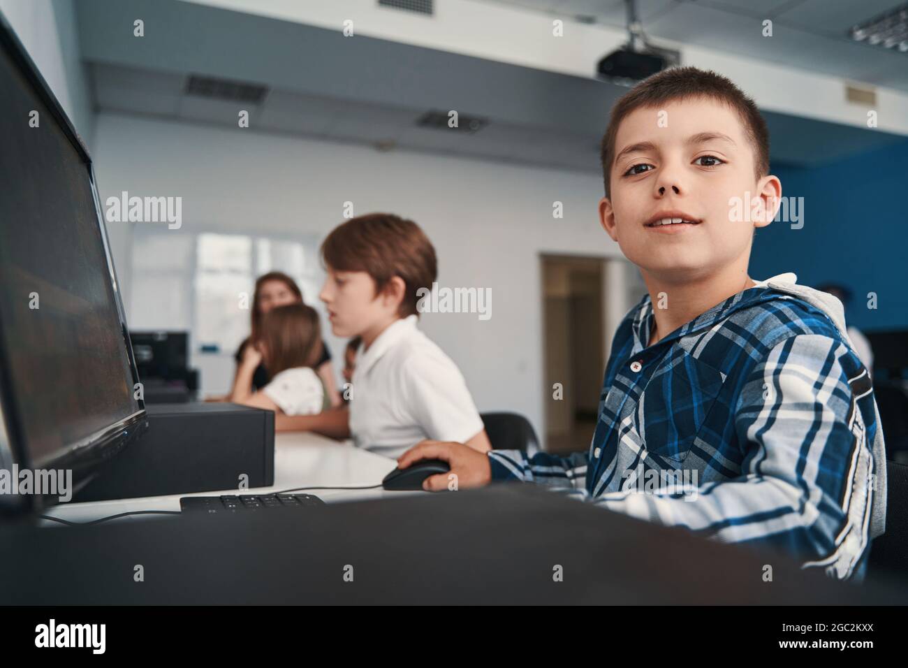 Clever boy feeling confident at ICT lessons Stock Photo - Alamy