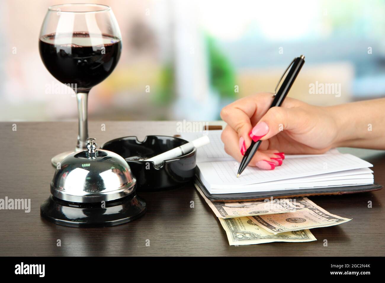 Hand signing in notebook, on bright background Stock Photo - Alamy