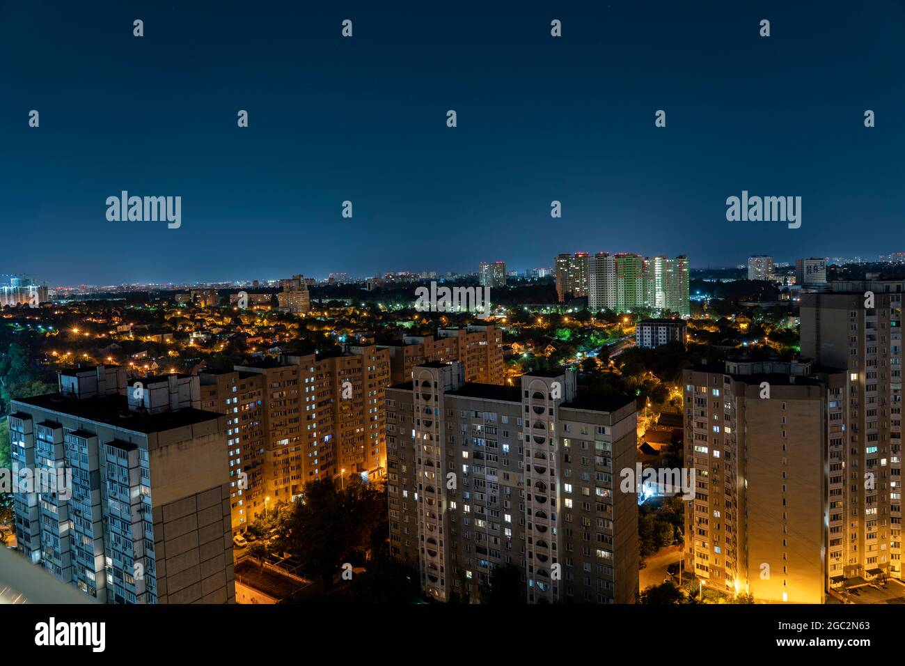Night cityscape, lights from windows of houses, stars in the sky ...