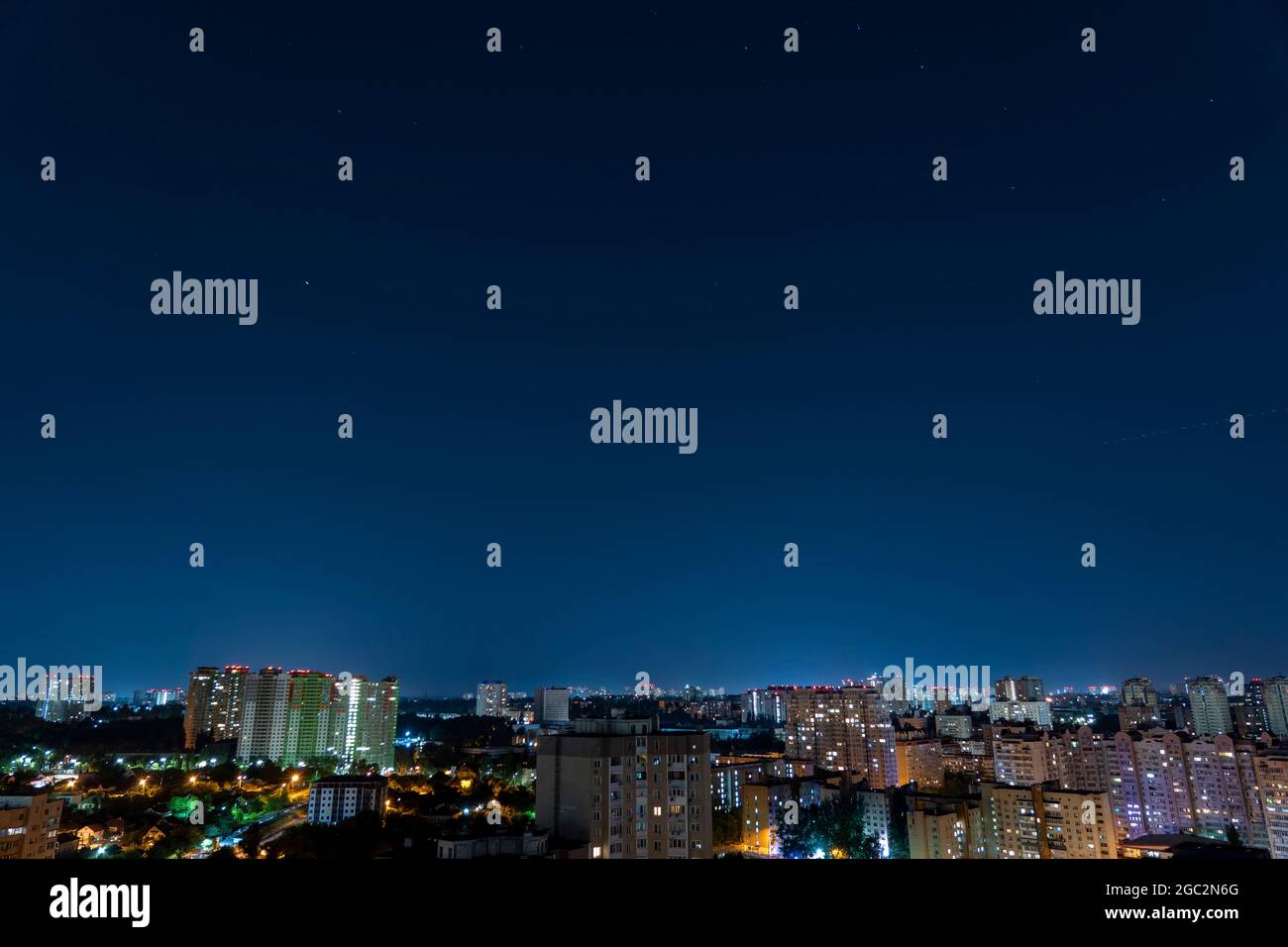Night cityscape, lights from windows of houses, stars in the sky ...