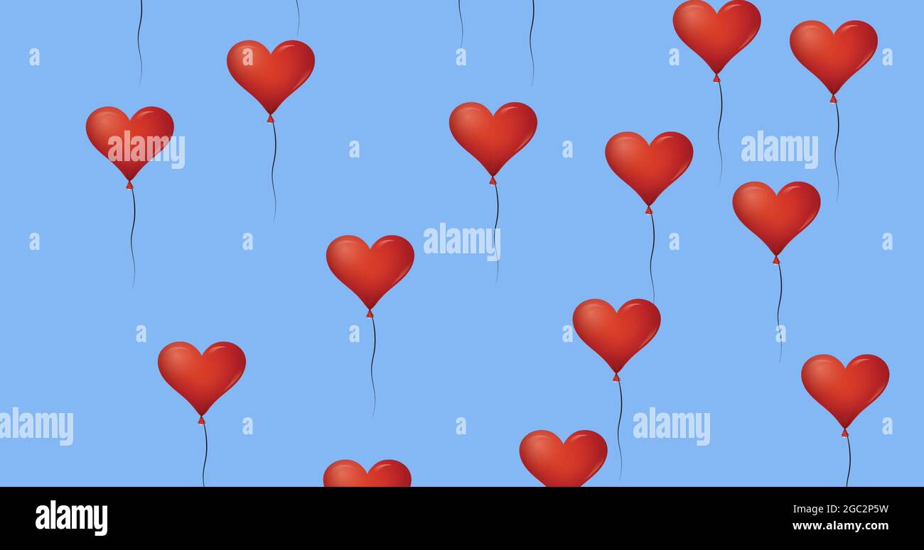 Multiple heart shaped balloons floating against silhouette of two woman ...