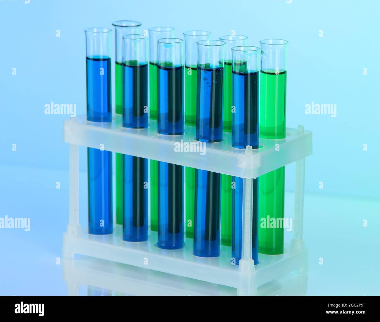 Identical test tubes on blue background Stock Photo - Alamy