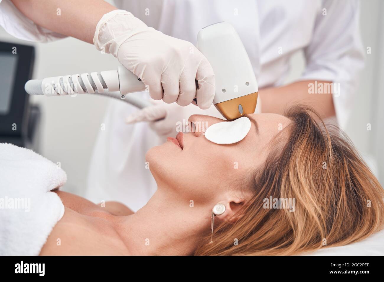 Pretty female during laser procedures with cosmetologist Stock Photo ...