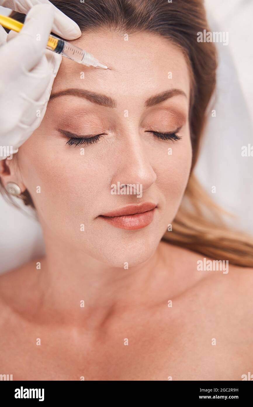 Happy pretty woman doing anti wrinkles procedures Stock Photo - Alamy