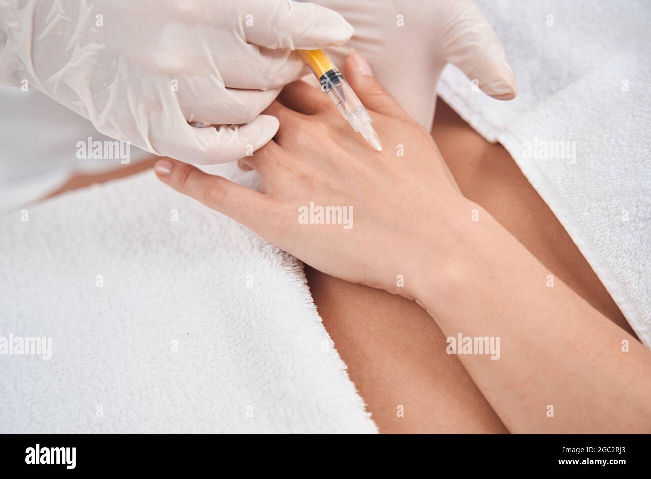 Woman doing beauty injection into arms in clinic Stock Photo - Alamy