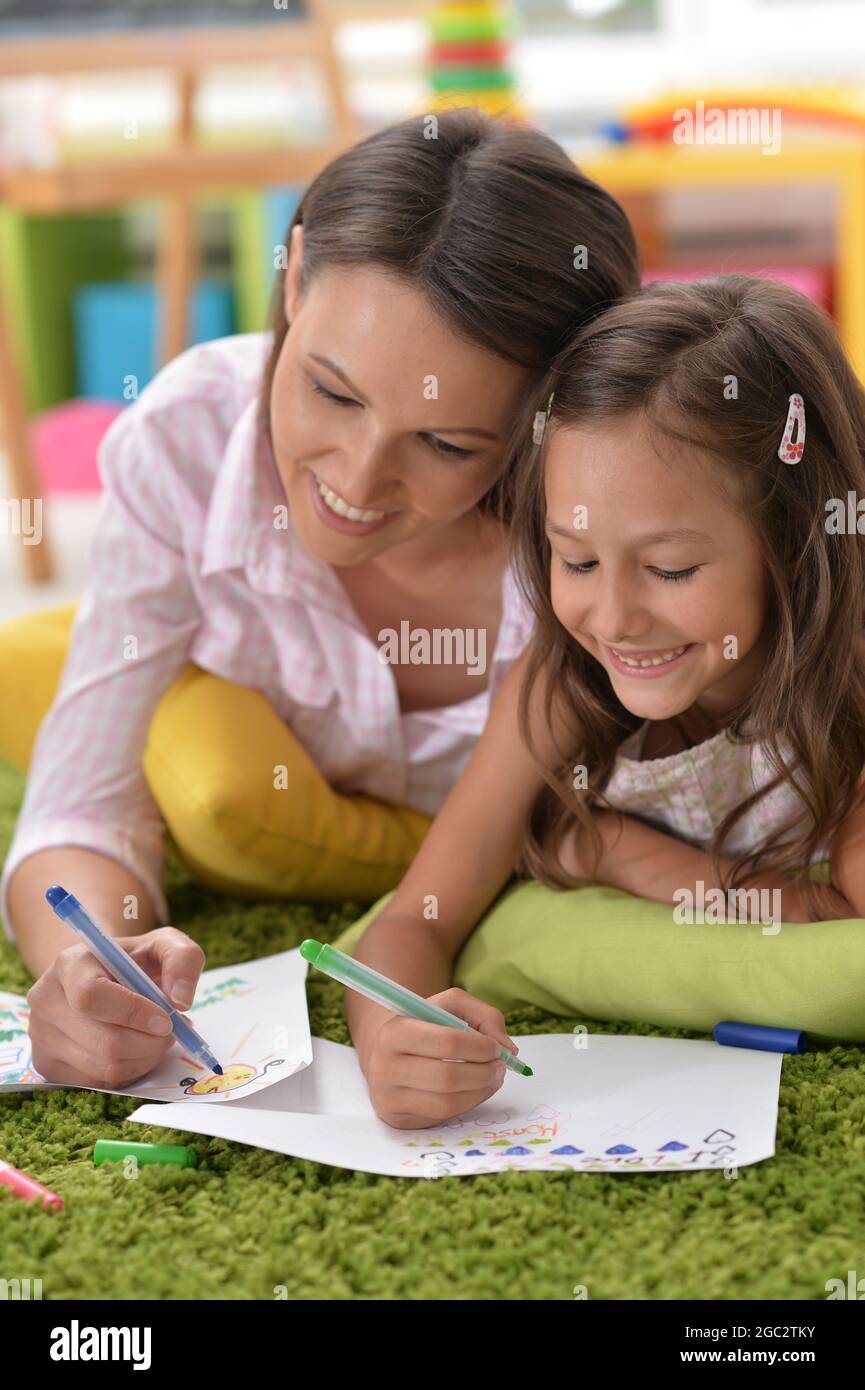 Cute girl with mother drawing at home Stock Photo - Alamy