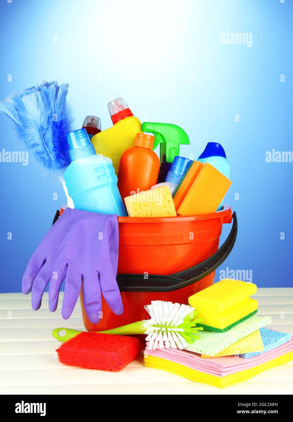 Cleaning items in bucket on color background Stock Photo - Alamy