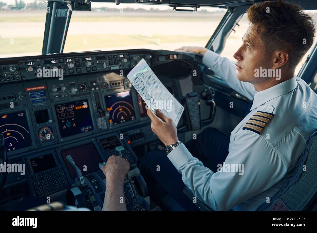 Two licensed pilots seated in the flight deck Stock Photo - Alamy