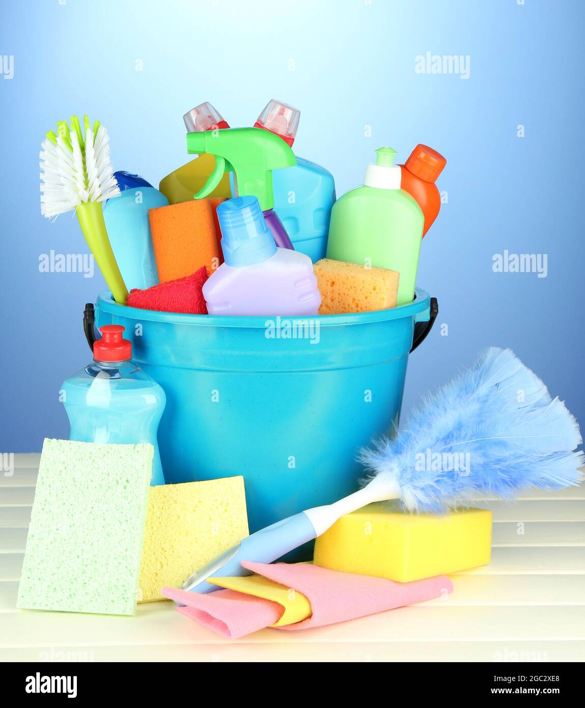 Cleaning items in bucket on color background Stock Photo - Alamy