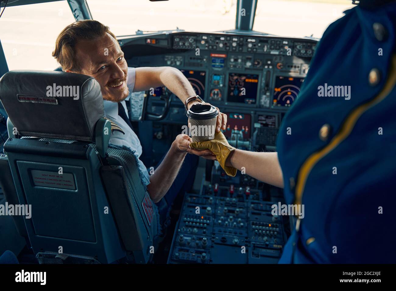 Airline captain being served coffee in the cockpit Stock Photo - Alamy