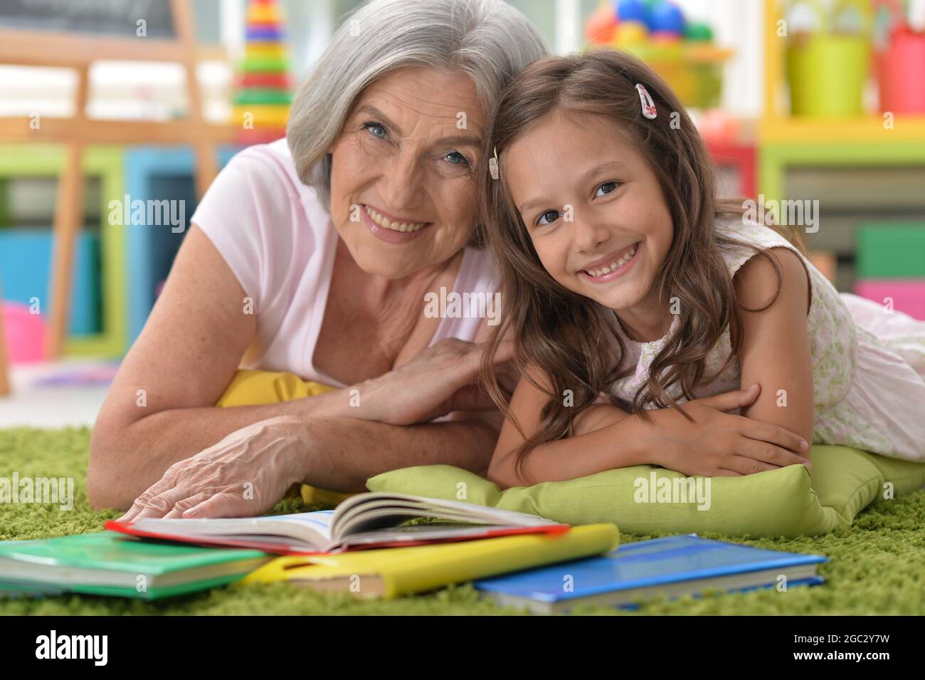 Portrait of cute grandmother with granddaughter with books Stock Photo ...