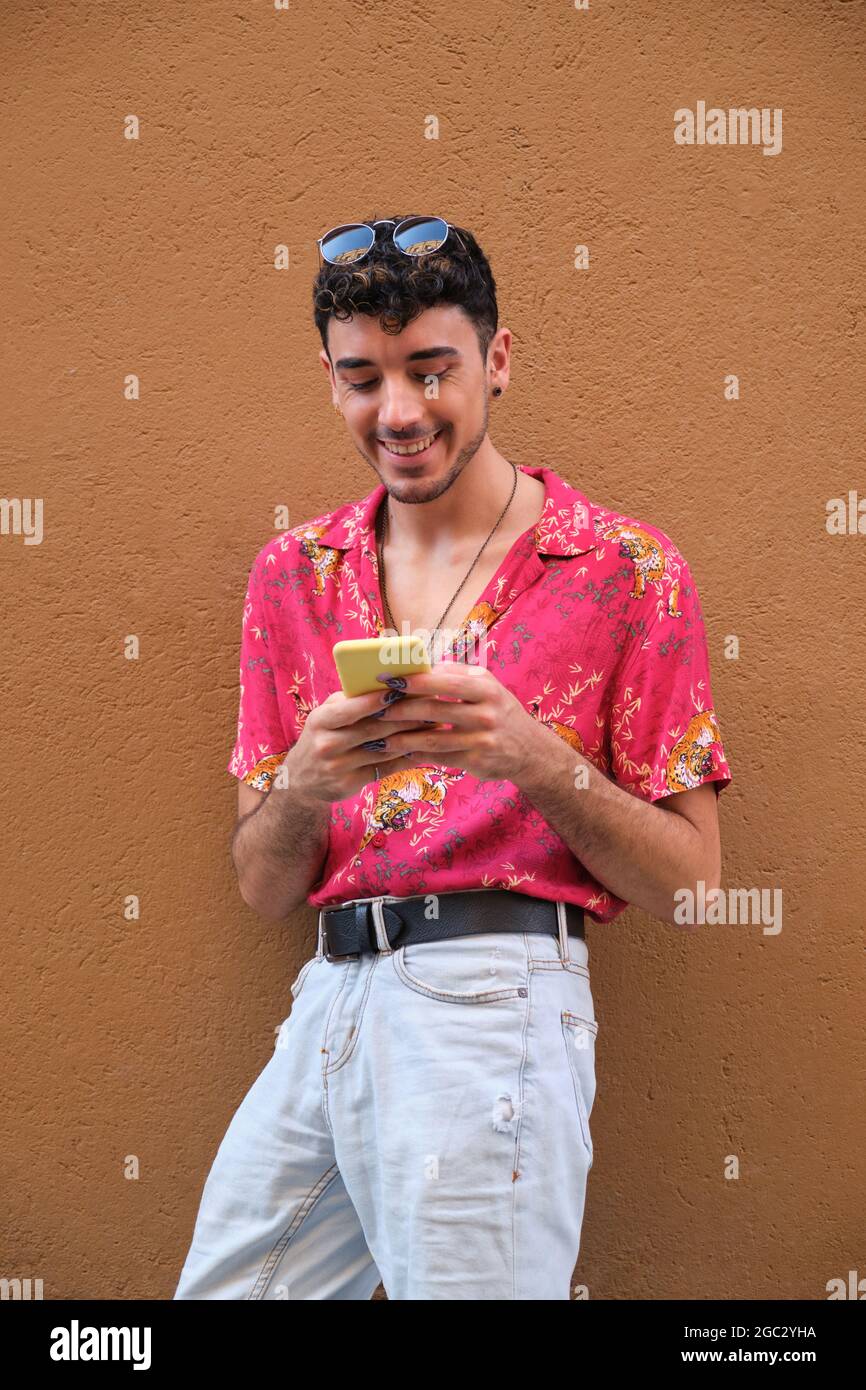 Young caucasian man with long false nails smiling and chatting on the ...