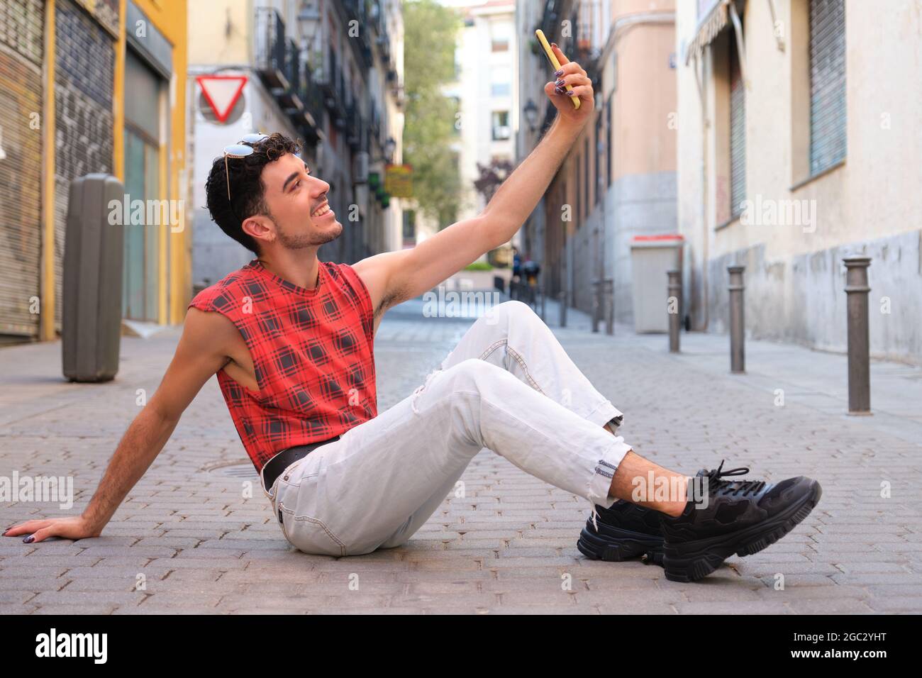 Young caucasian man with long false nails taking a selfie sitting on ...