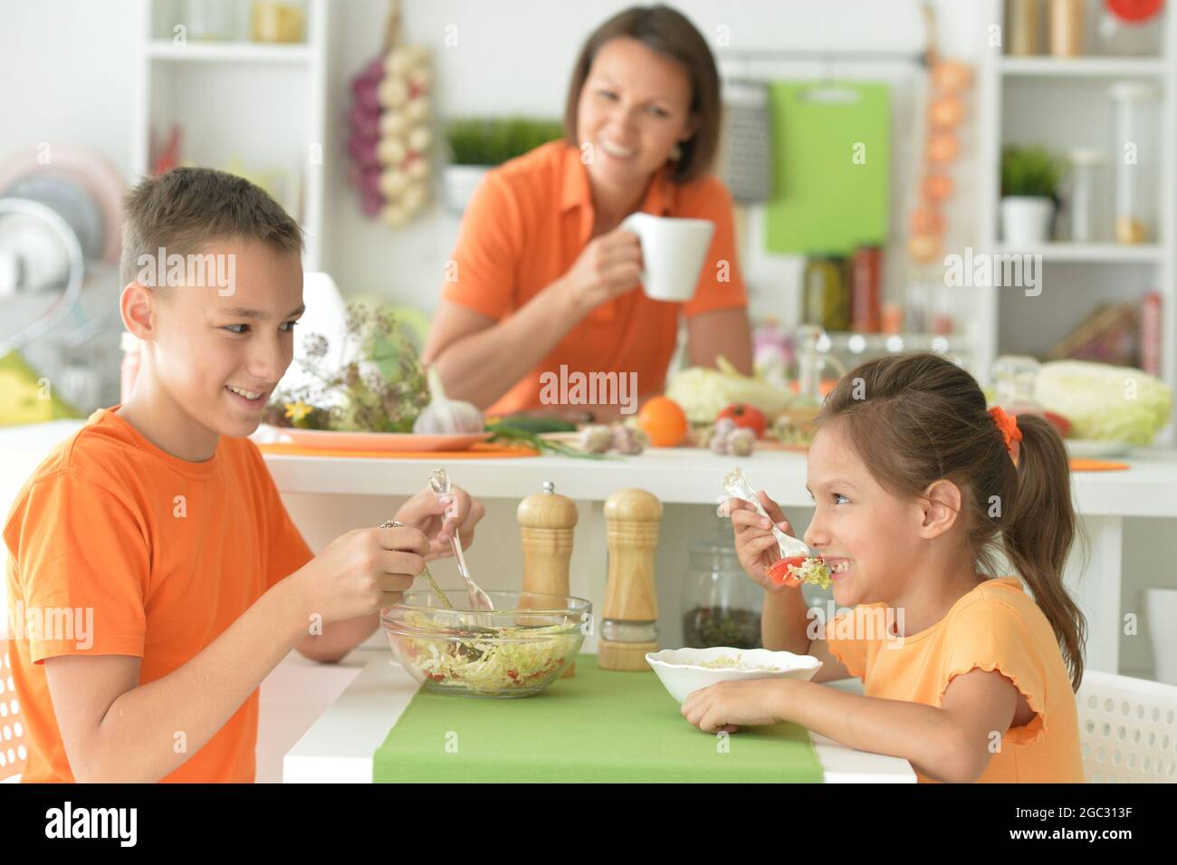 Portrait of happy family eating breakfast at home Stock Photo - Alamy