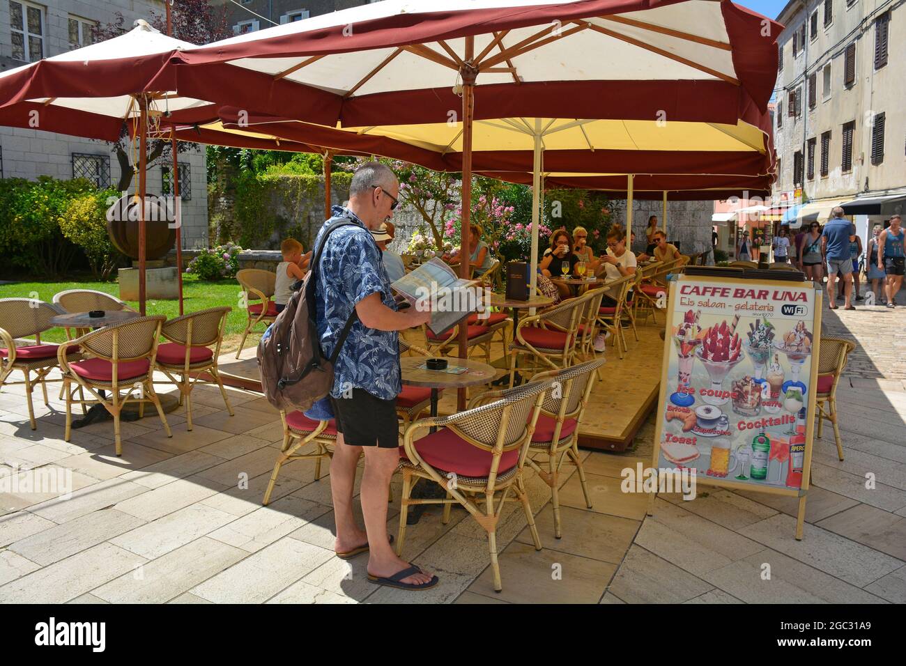 Porec, Croatia - July 10th 2021. A tourist looks at a menu outside a ...