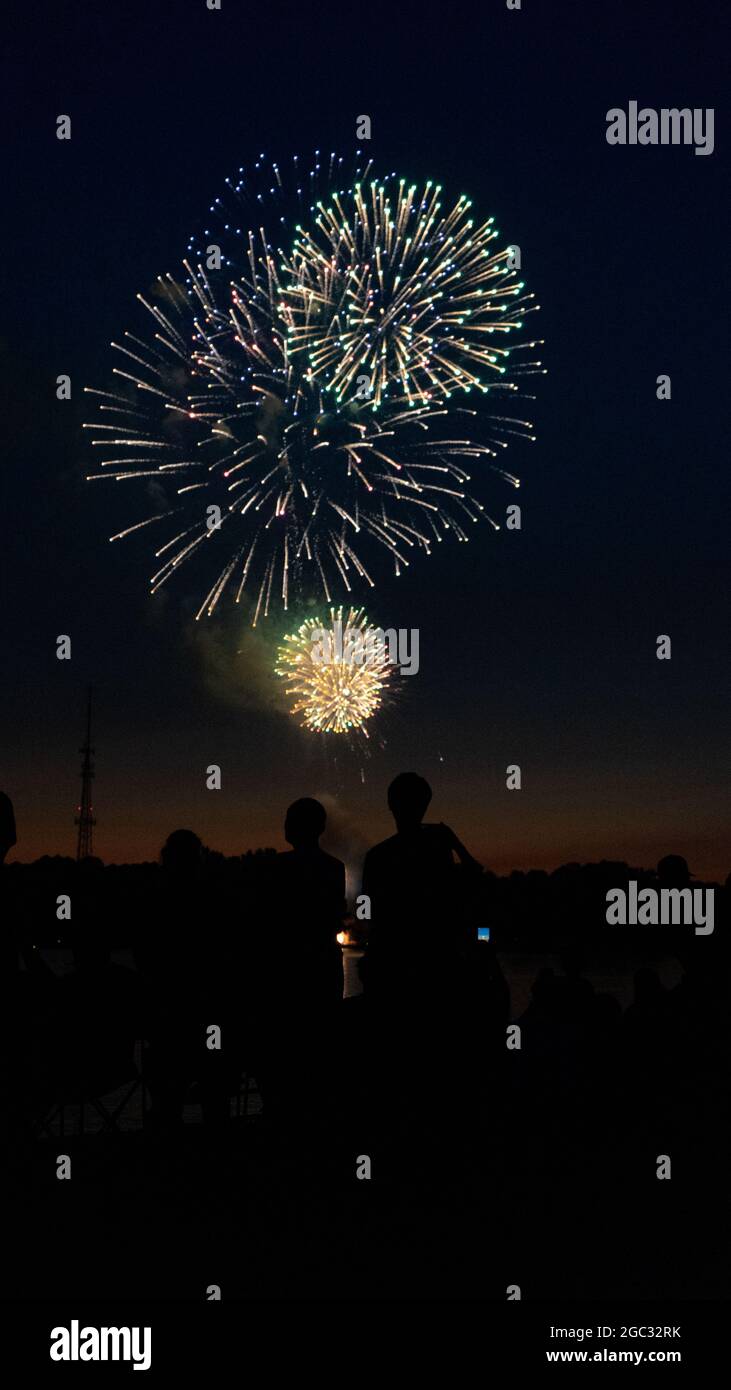 Vertical background of beautiful fireworks show on a blue night sky ...