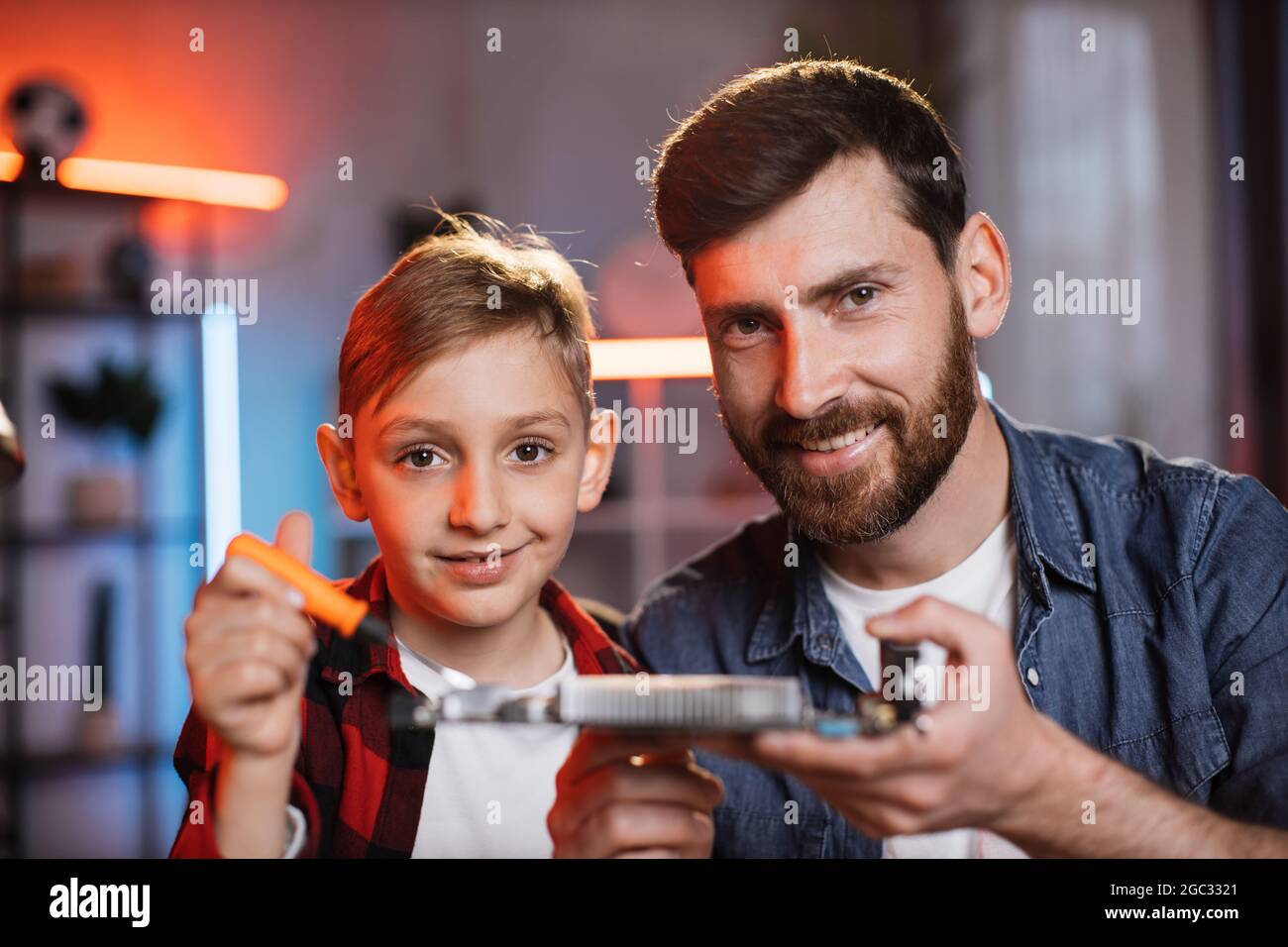 Portrait of smiling father with lovely son holding display card in ...
