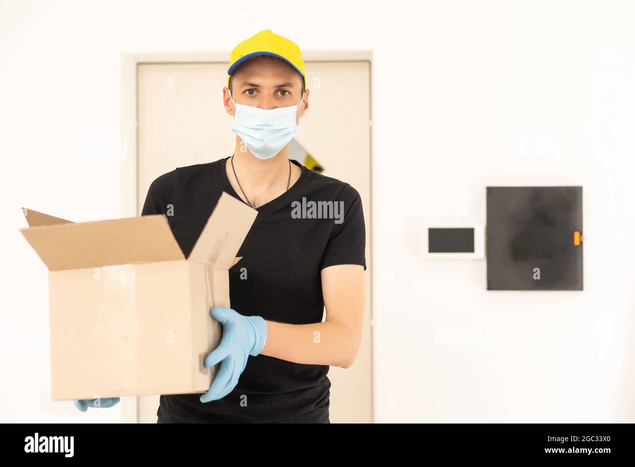 delivery man holding package to deliver. Courier hand holding brown box ...