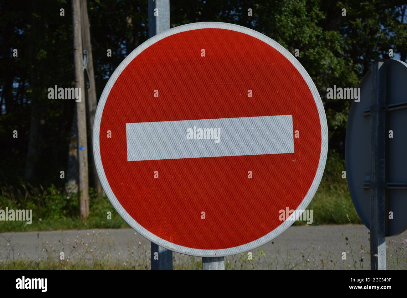 Round metal red no entry sign on the side of the road Stock Photo - Alamy