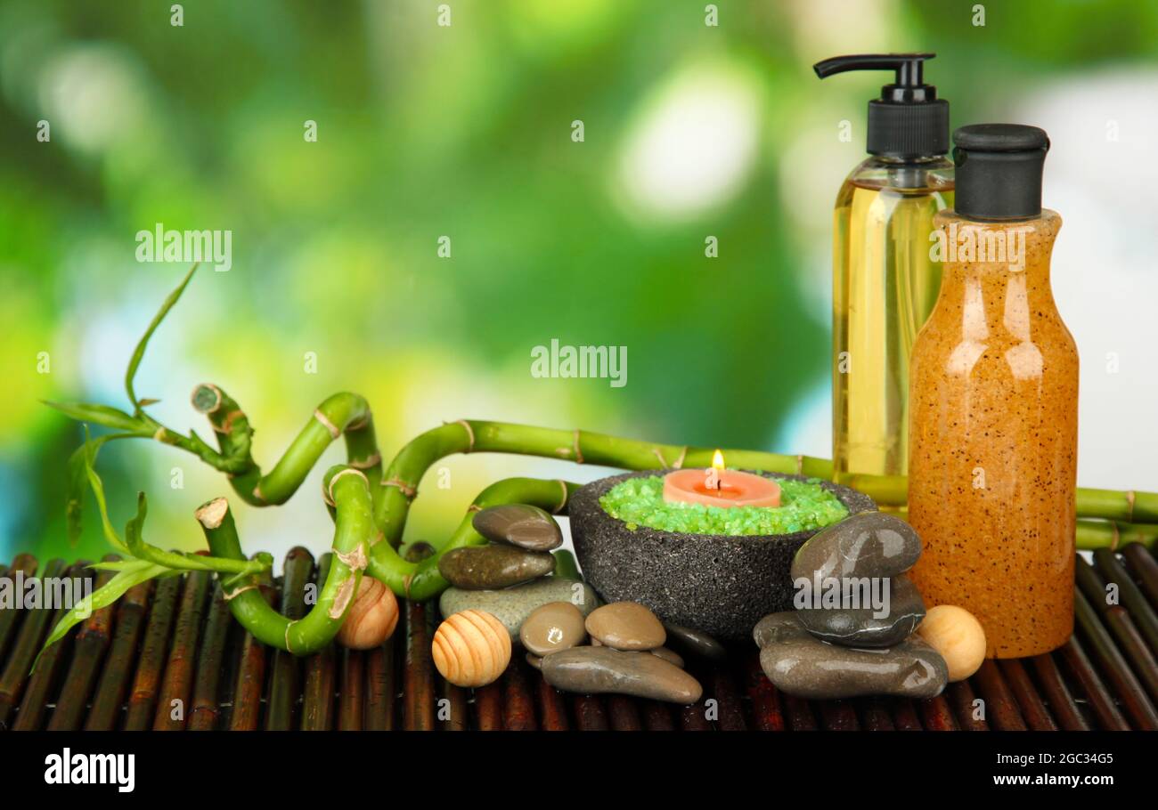 Still life with green bamboo plant and stones, on bamboo mat, on bright ...