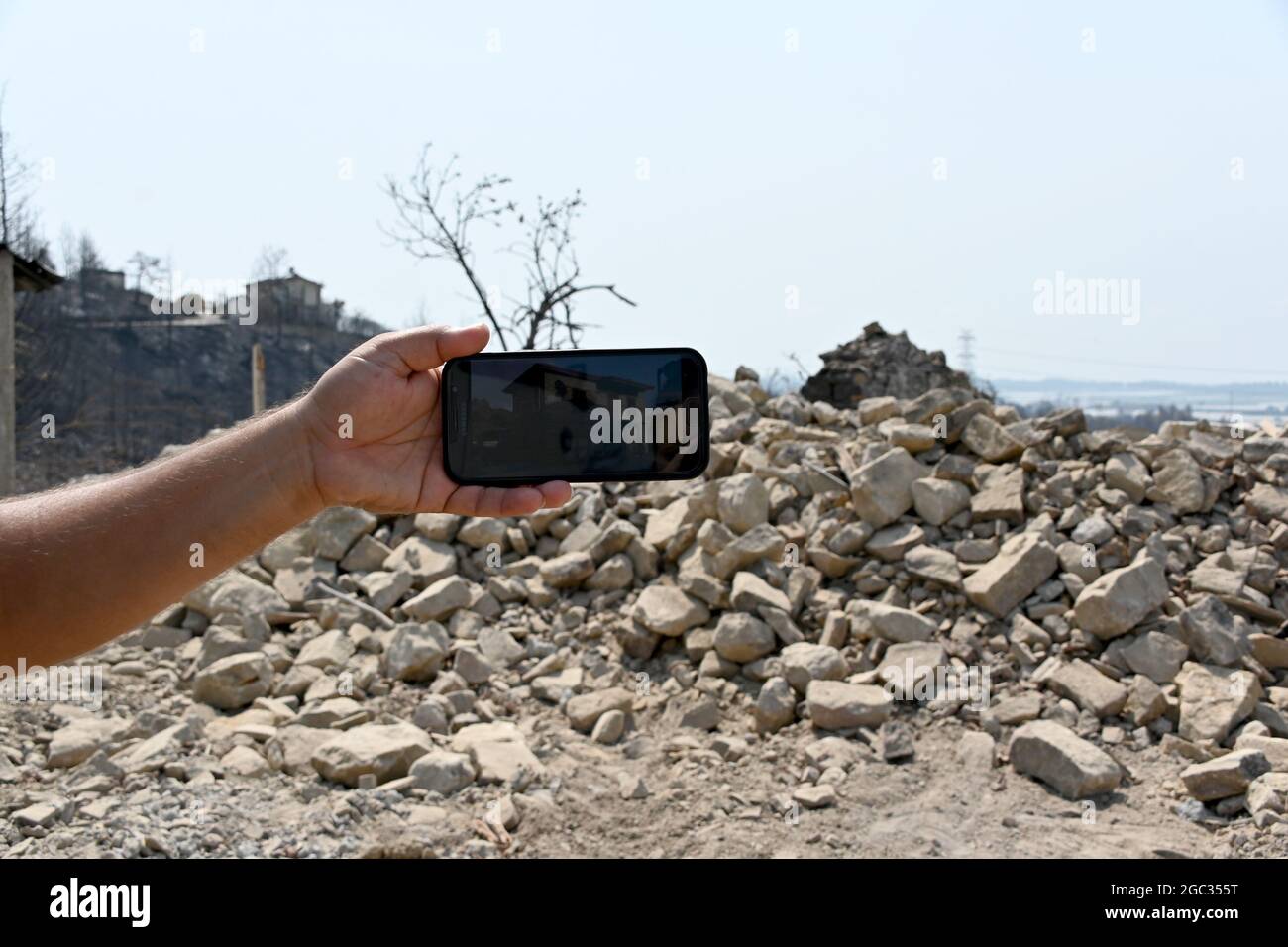 Kalemler, Turkey. 06th Aug, 2021. Ibrahim Özbay shows a picture on his ...