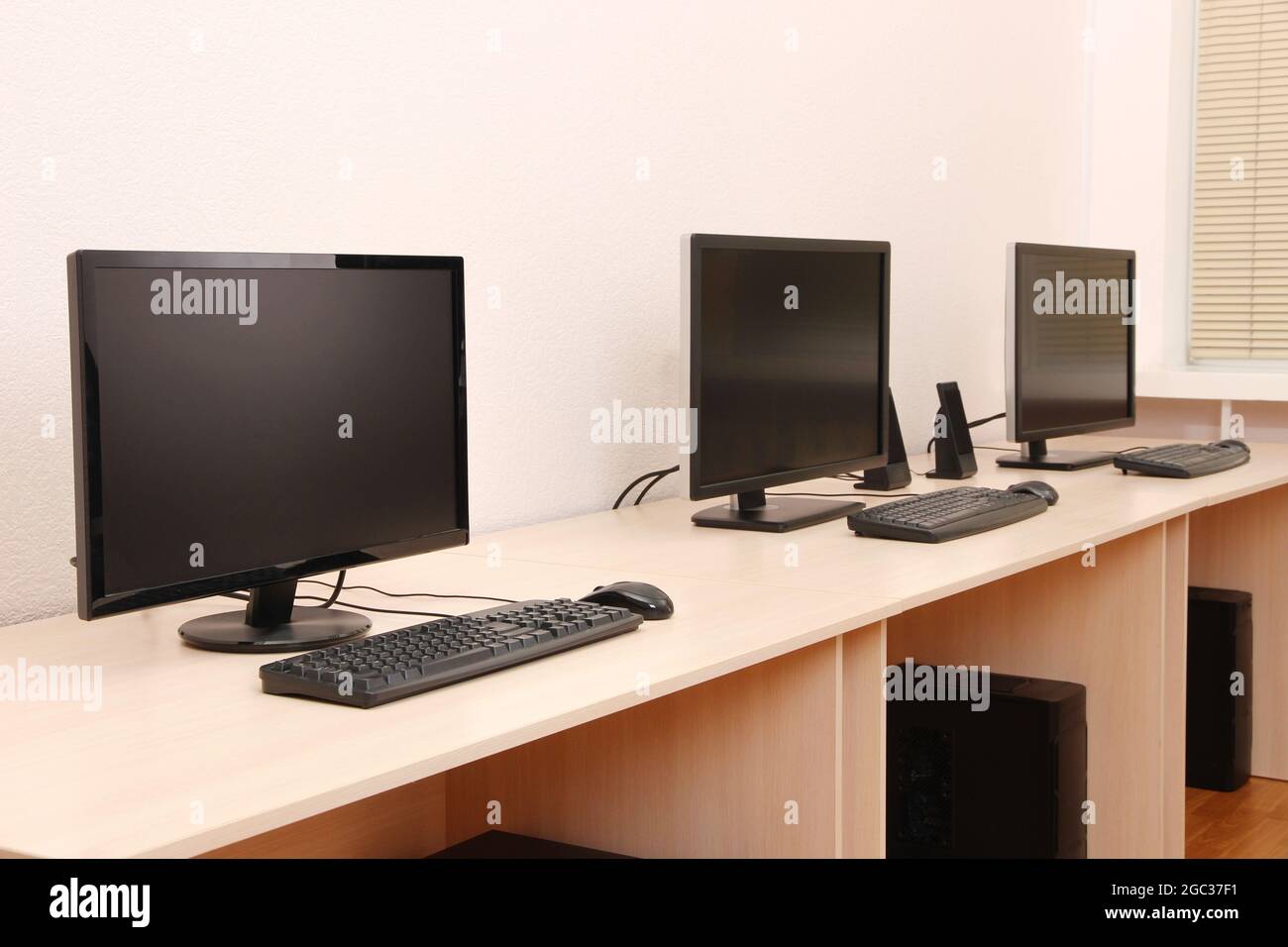 Computers on tables in room Stock Photo - Alamy